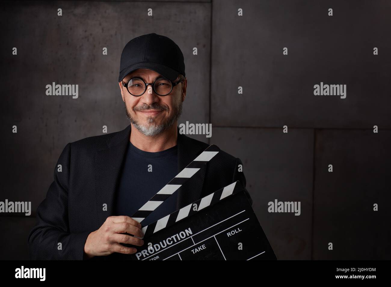 Happy man holding black clapper board. Movie director starting film ...