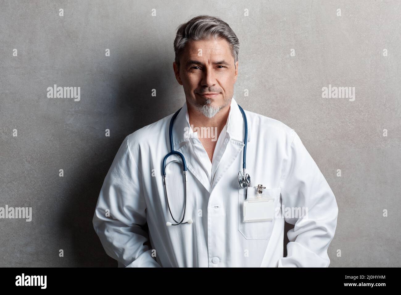Portrait of trustworthy older confident doctor with gray hair wearing ...