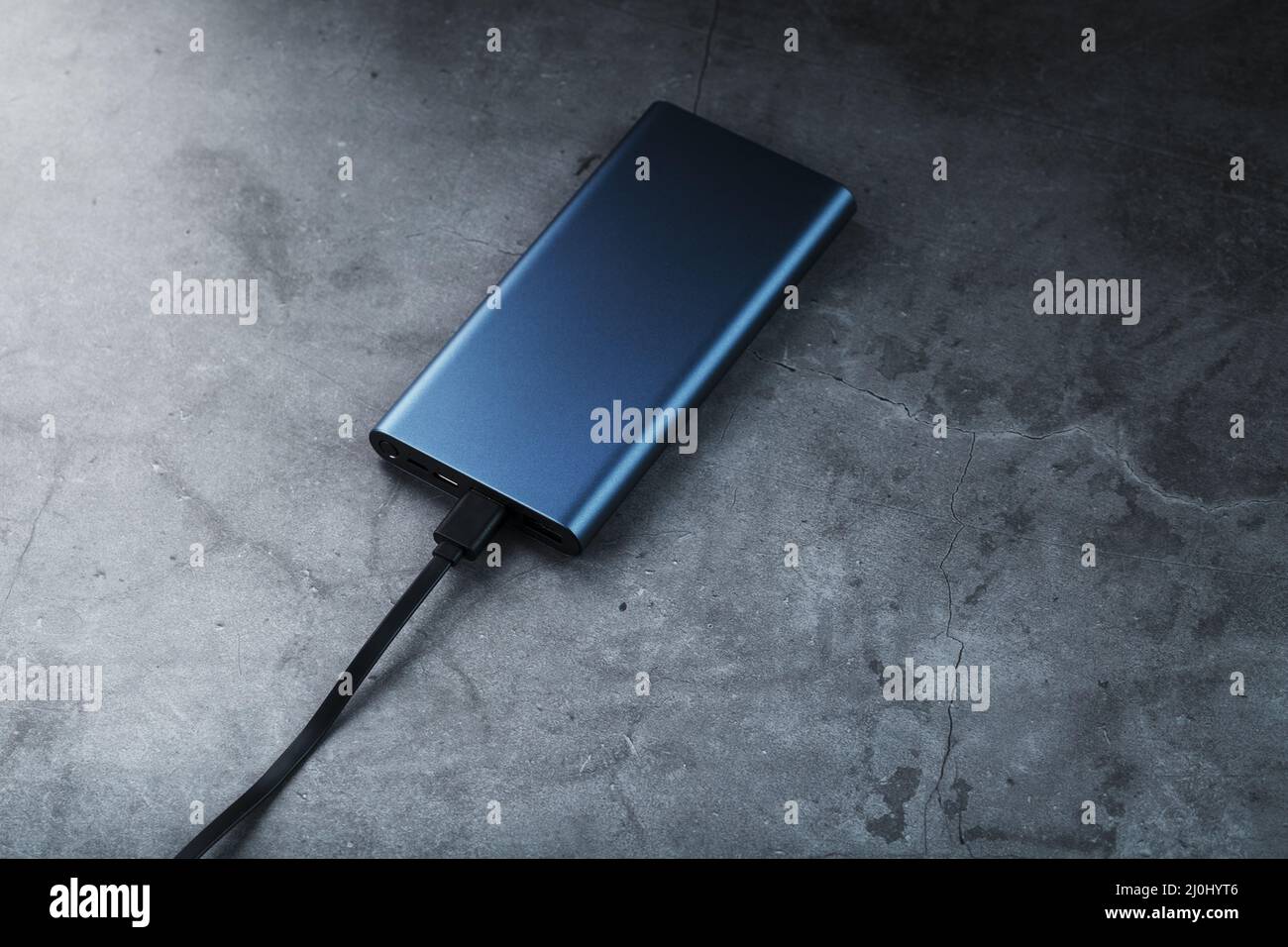 Portable External Battery Power Bank blue with USB Cord on a dark ...