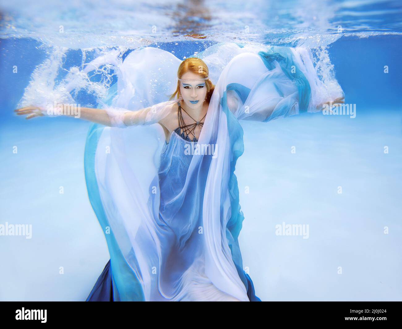 Underwater fashion portrait of beautiful blonde young woman in blue ...
