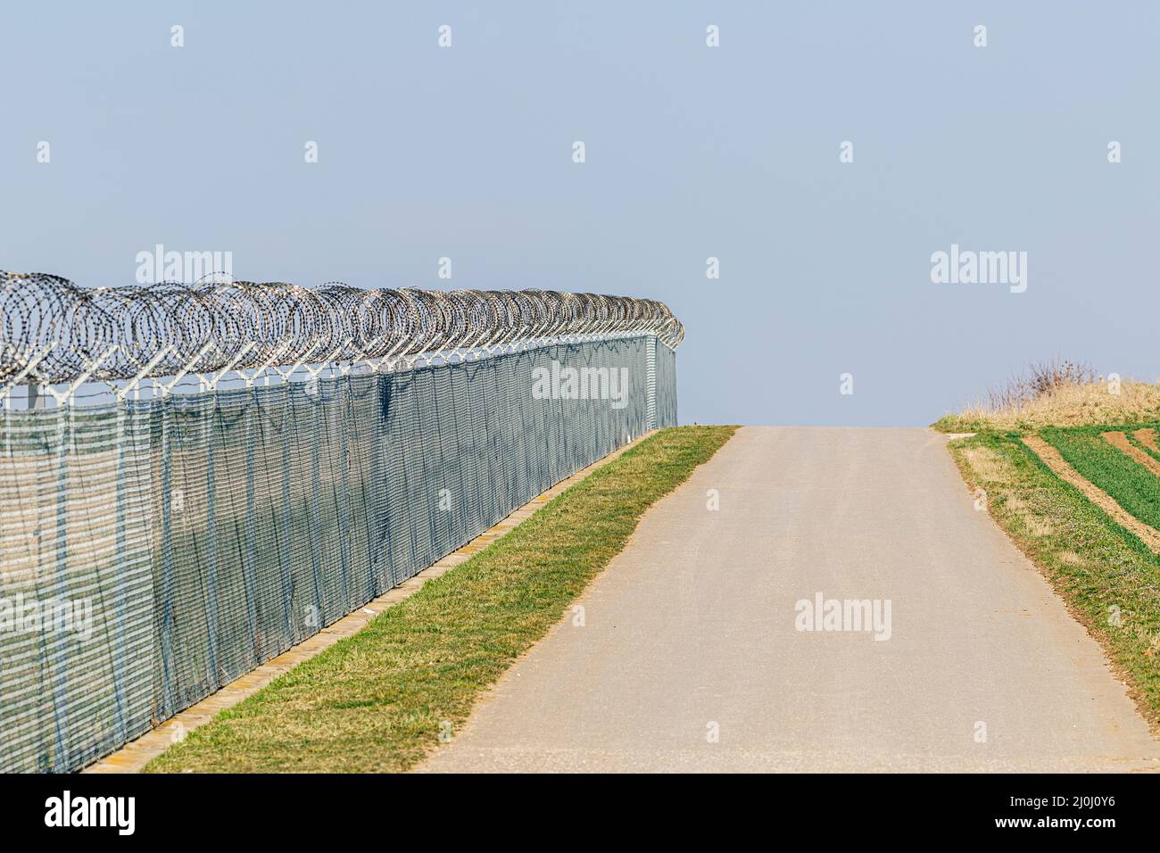 a barbed wire fence to protect a border Stock Photo - Alamy