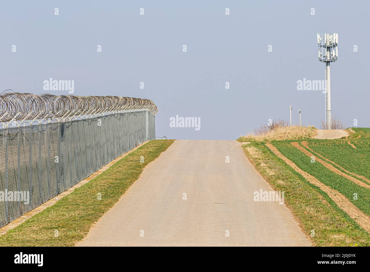 a barbed wire fence to protect a border Stock Photo - Alamy