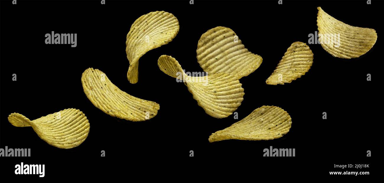 Ridged potato chips isolated on black background Stock Photo - Alamy