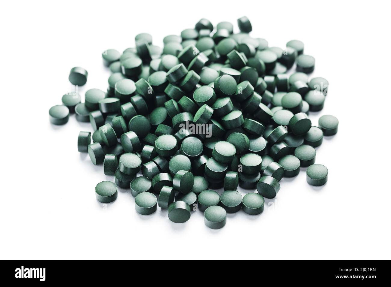 Green tablets made of natural organic spirulina on a white background ...