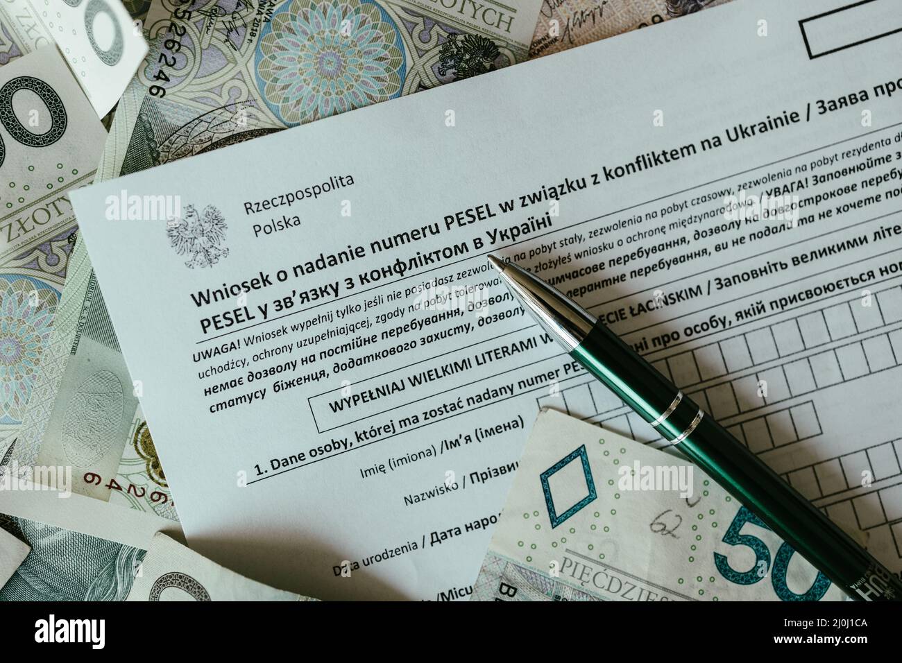 PESEL document with a pen and a Polish banknote money in the background ...