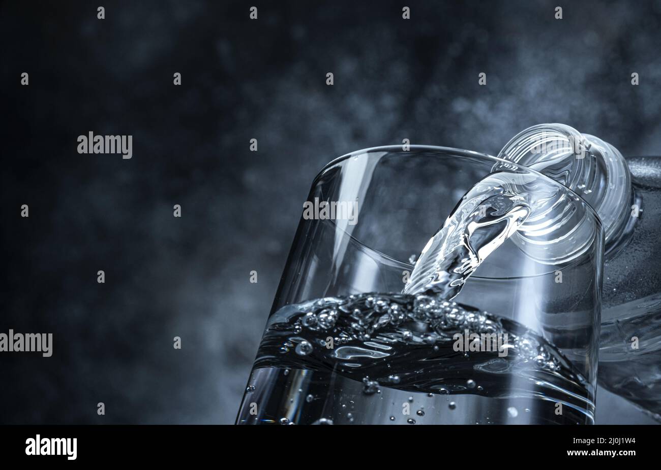 Pouring water on black background with copy space Stock Photo - Alamy