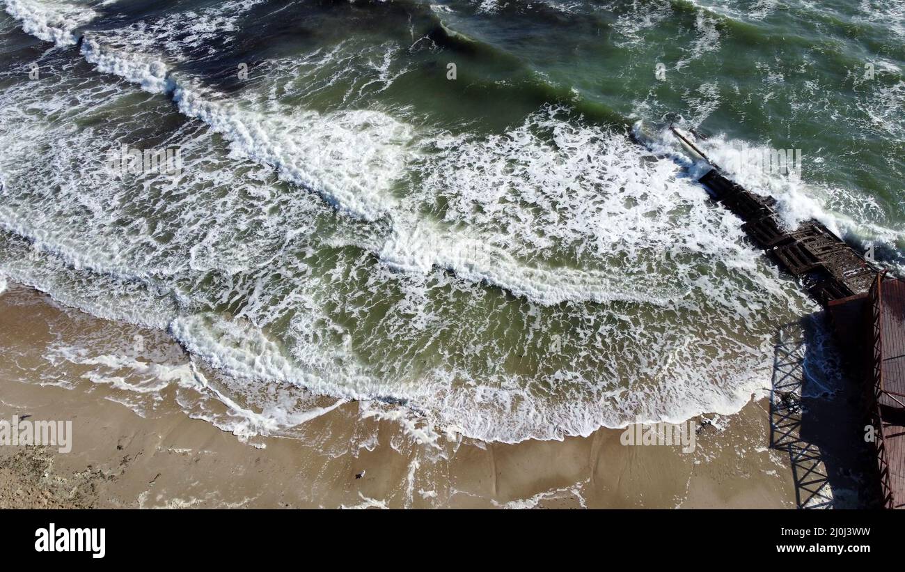 Aerial drone view flight over waves that roll onto the sandy shore. Top ...