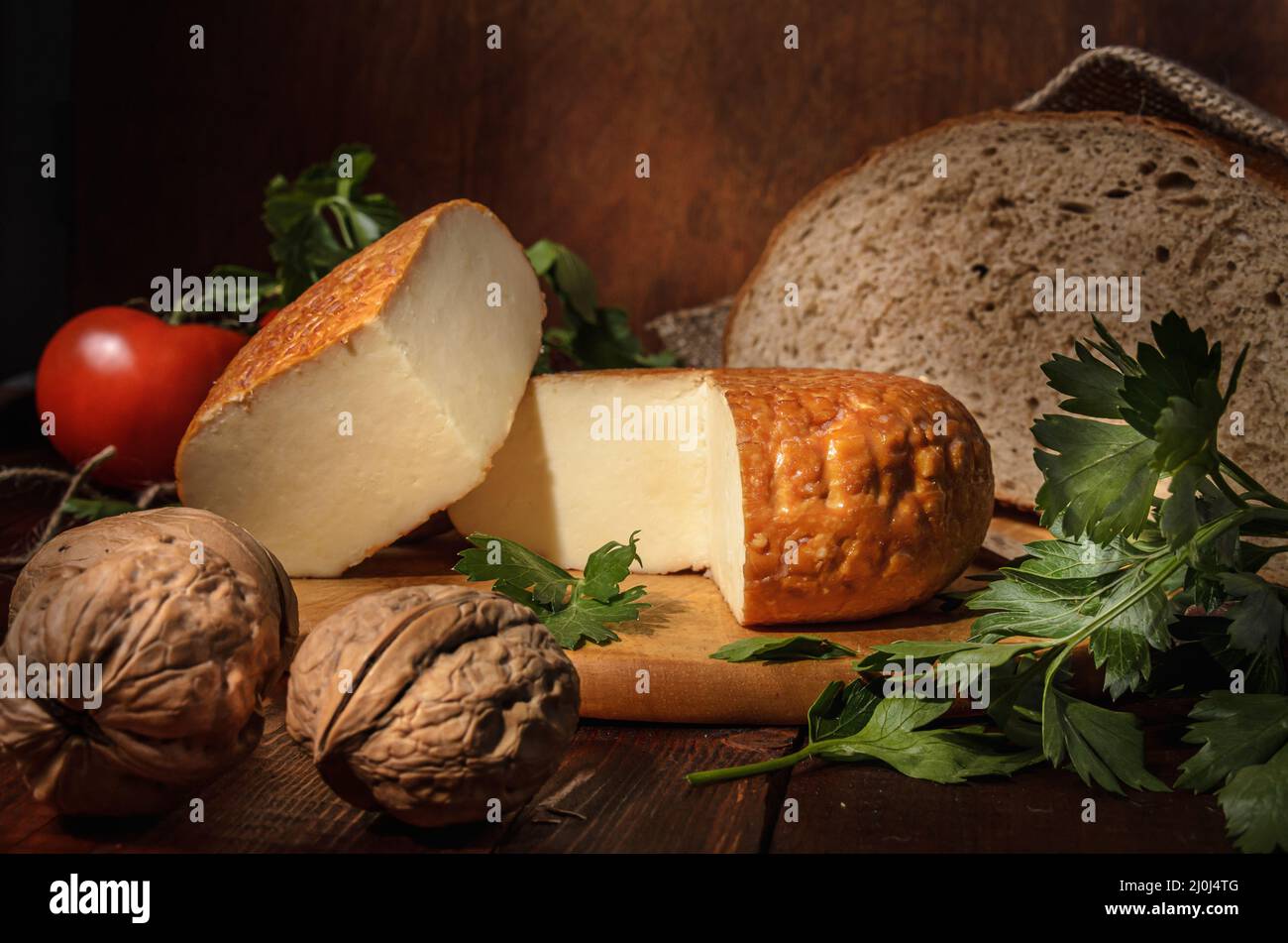 Circle of cheese on a cutting board in a rustic style Stock Photo - Alamy