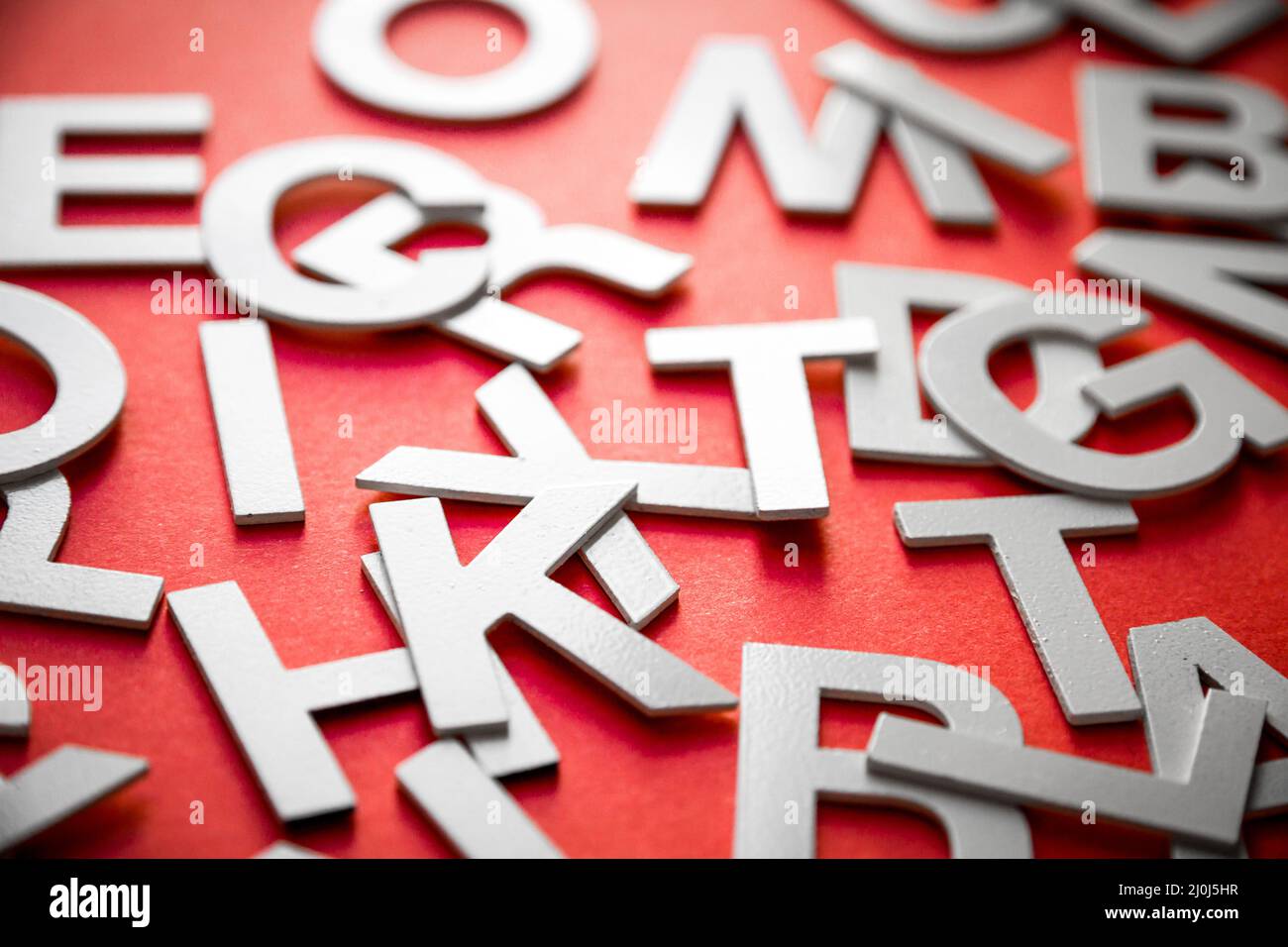 Mixed letters pile close up view photo. Red background Stock Photo - Alamy