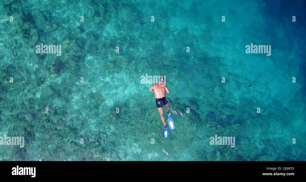 Top view of a man swimming with flippers in Rasdhoo Island, The ...