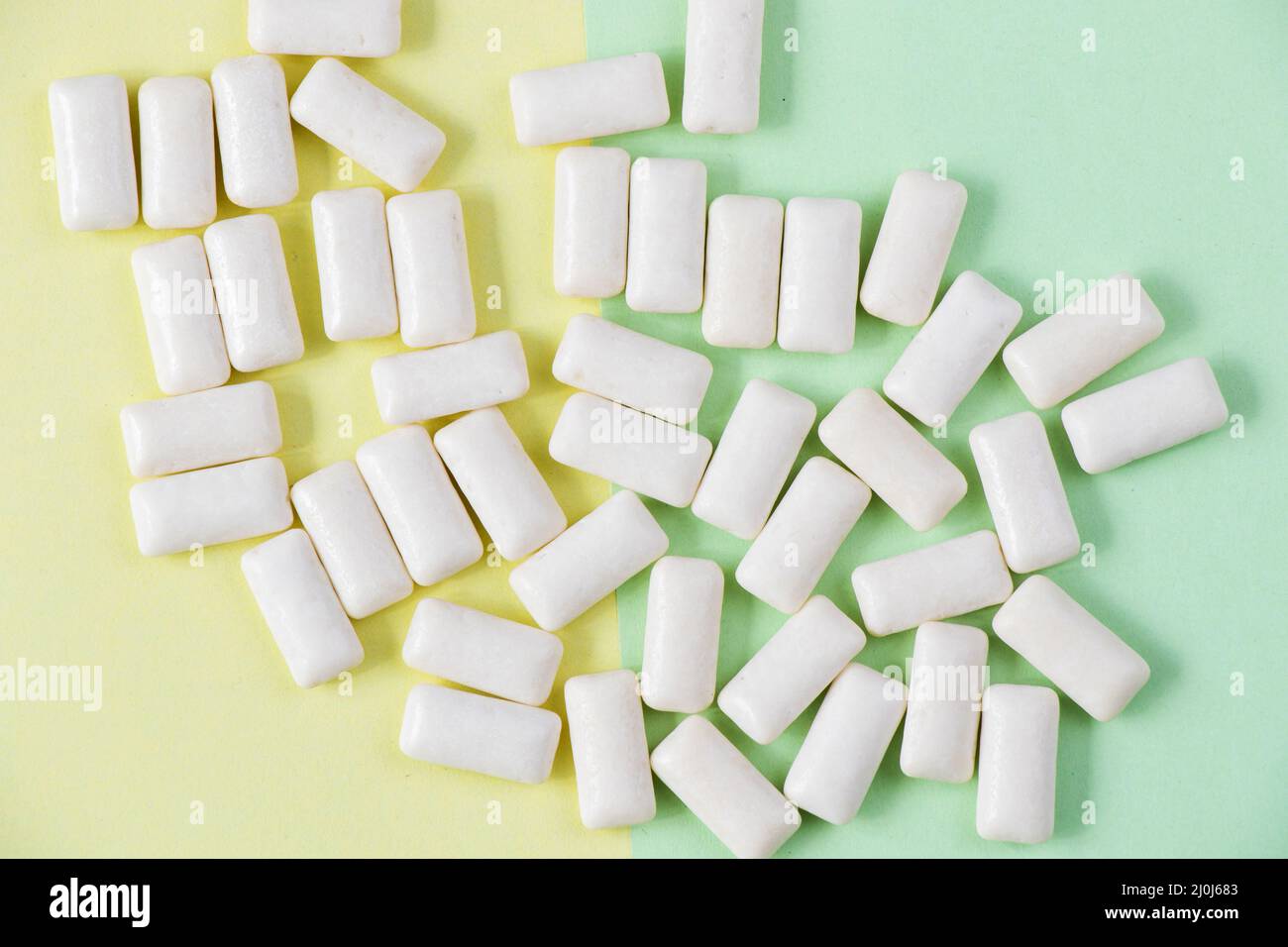 White chewing gums on the yellow and green background, high angle view ...