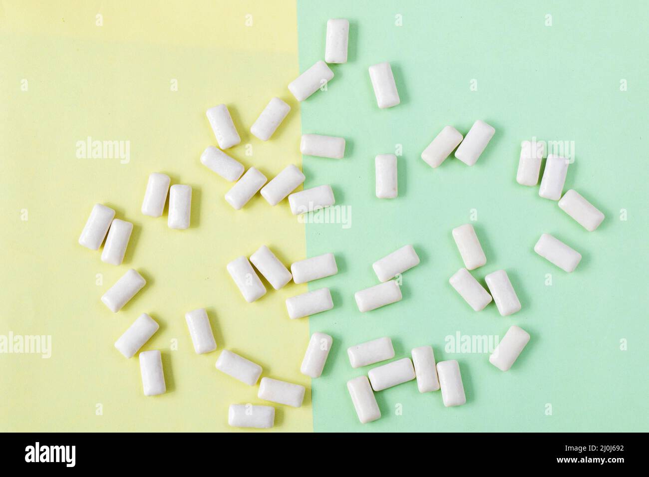 White chewing gums on the yellow and green background, high angle view ...