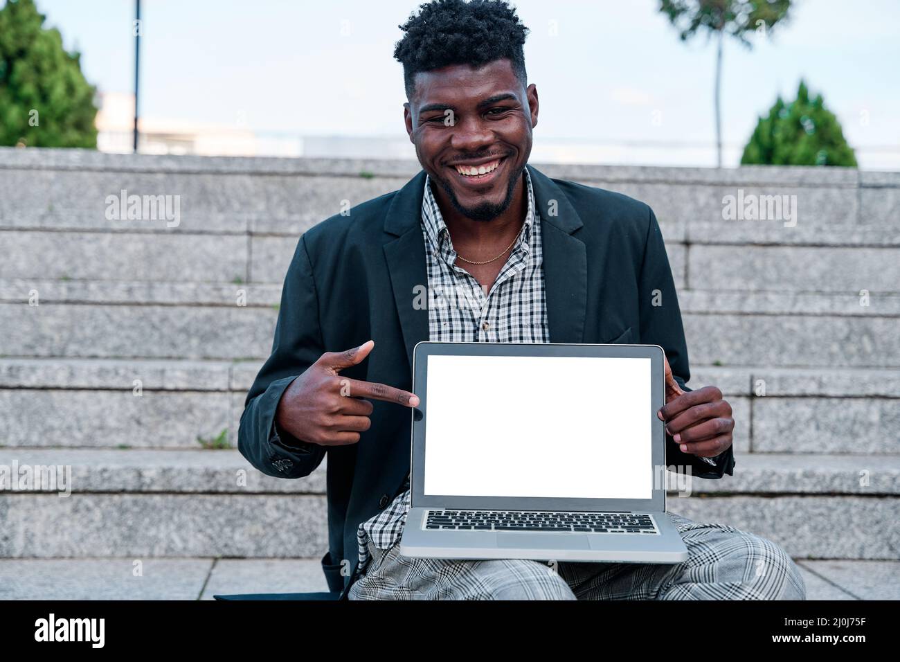 African-American man in suit, smiling and pointing at blank computer ...