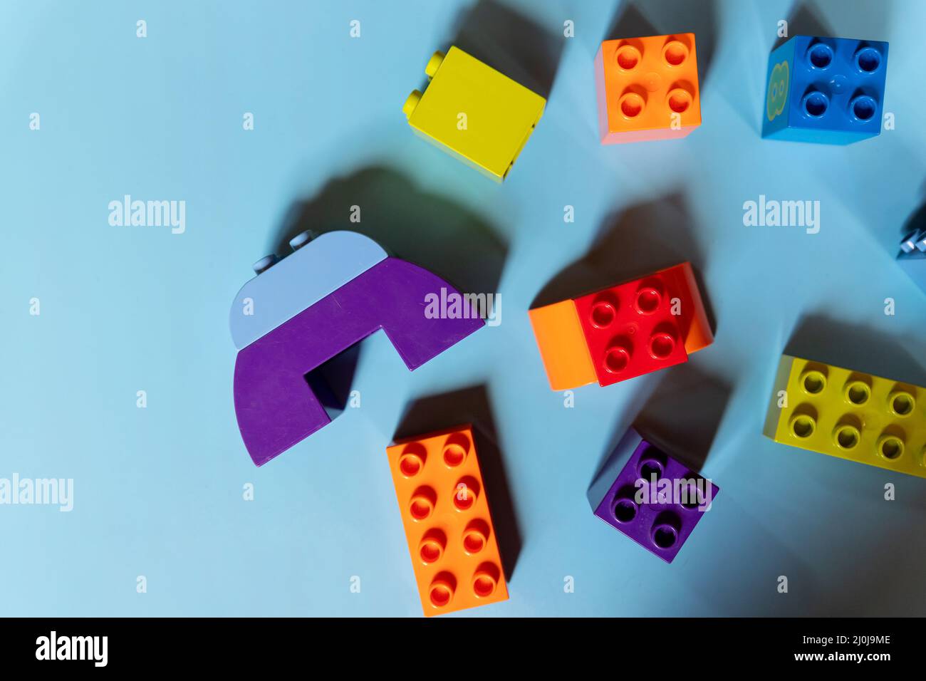 Colorful plastic building blocks flat lay. Yellow background. Child ...