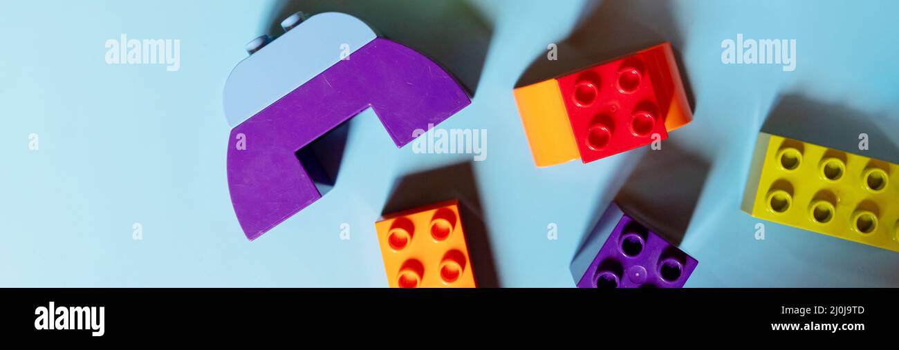 Colorful plastic building blocks flat lay. Yellow background. Child ...