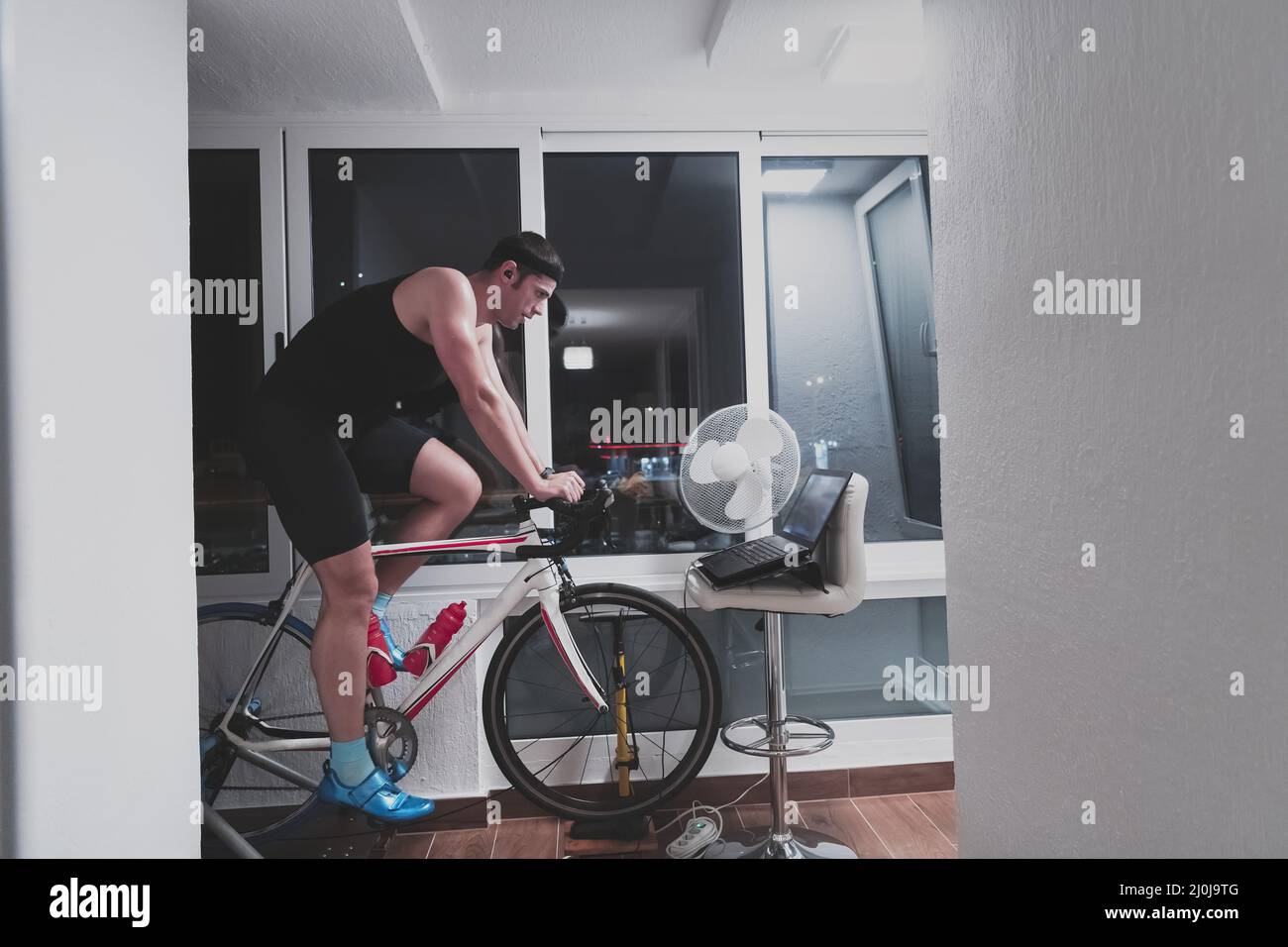 Man cycling on the machine trainer he is exercising in the home at ...