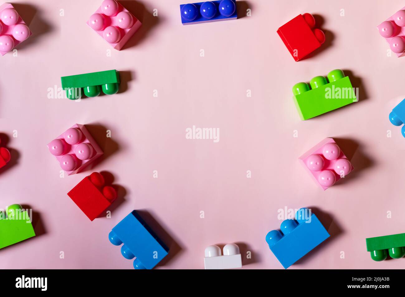 Colorful plastic building blocks flat lay. Yellow background. Child ...