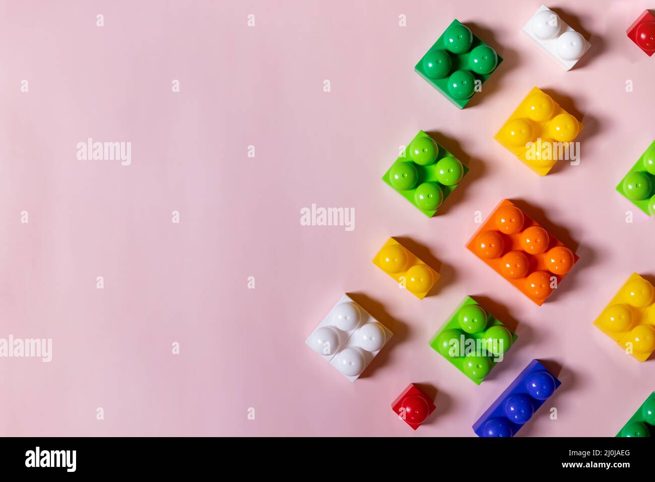 Colorful plastic building blocks flat lay. Yellow background. Child ...