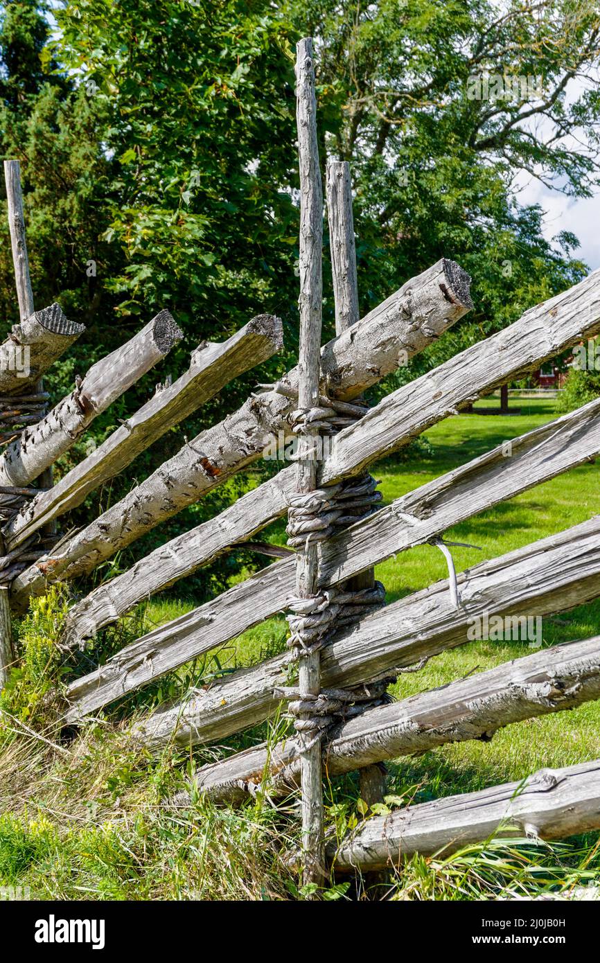 Traditional wooden fence made with rough logs and boards in the ...