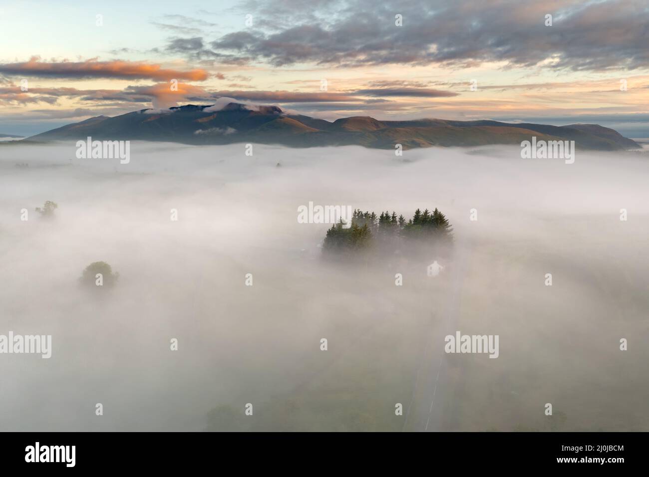 Breathtaking scenic view of misty valley in morning fog. Lake District ...