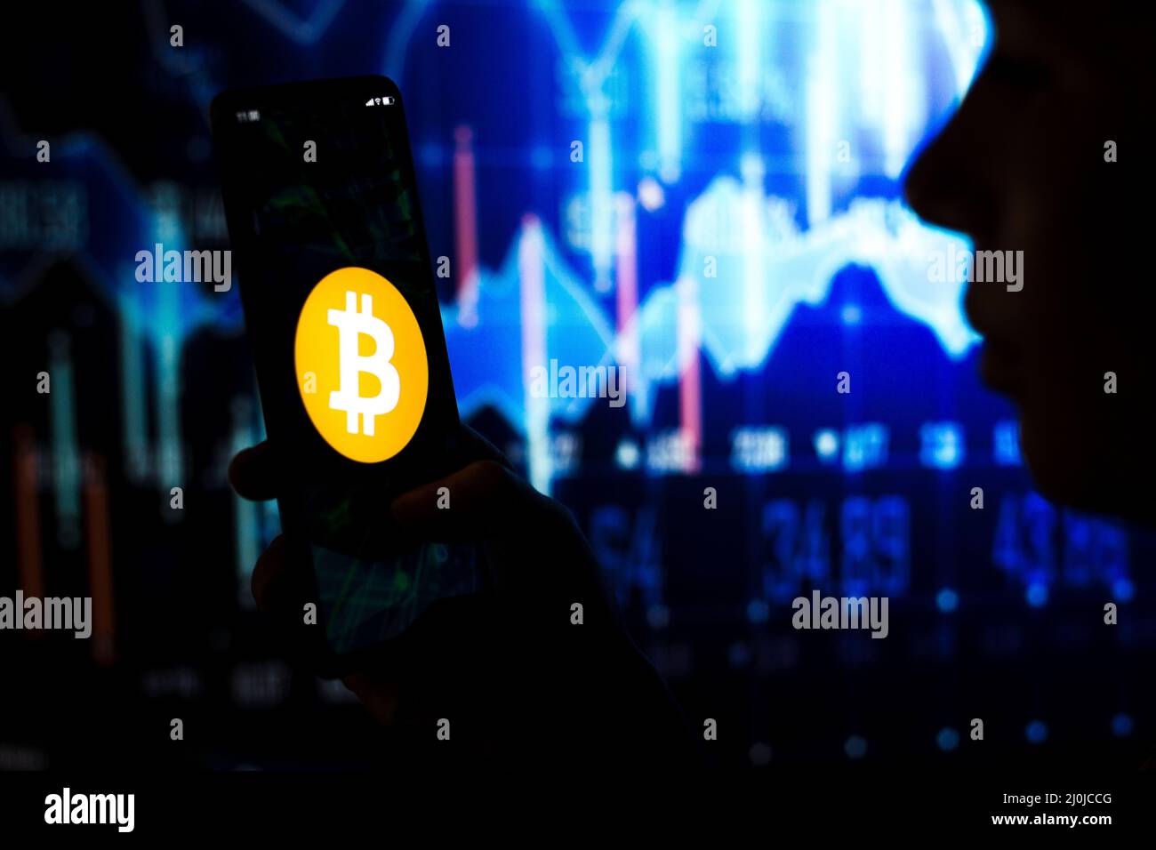 In this photo illustration, a woman holds a smartphone with the Bitcoin ...