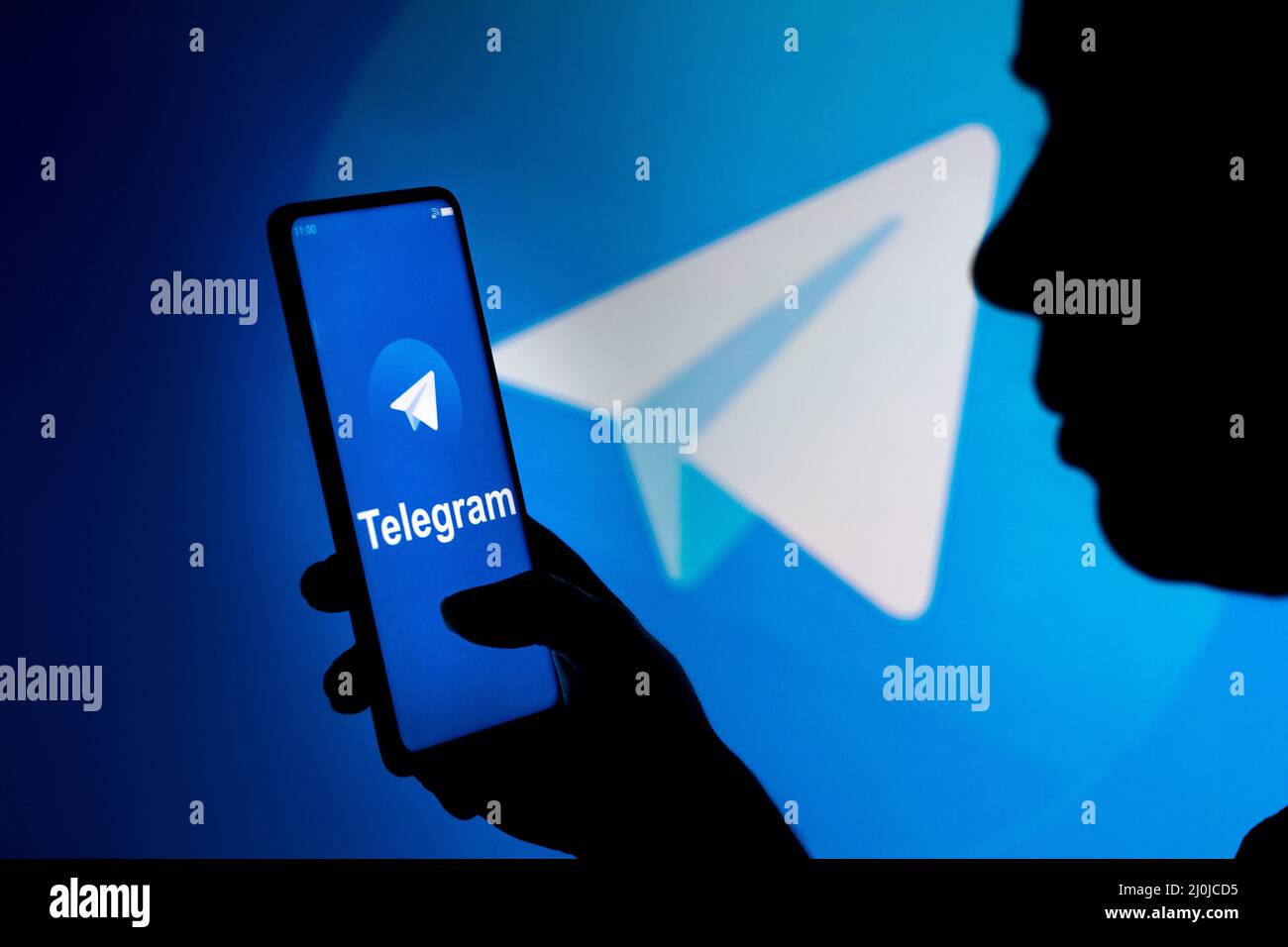 In this photo illustration, a woman holds a smartphone with the ...