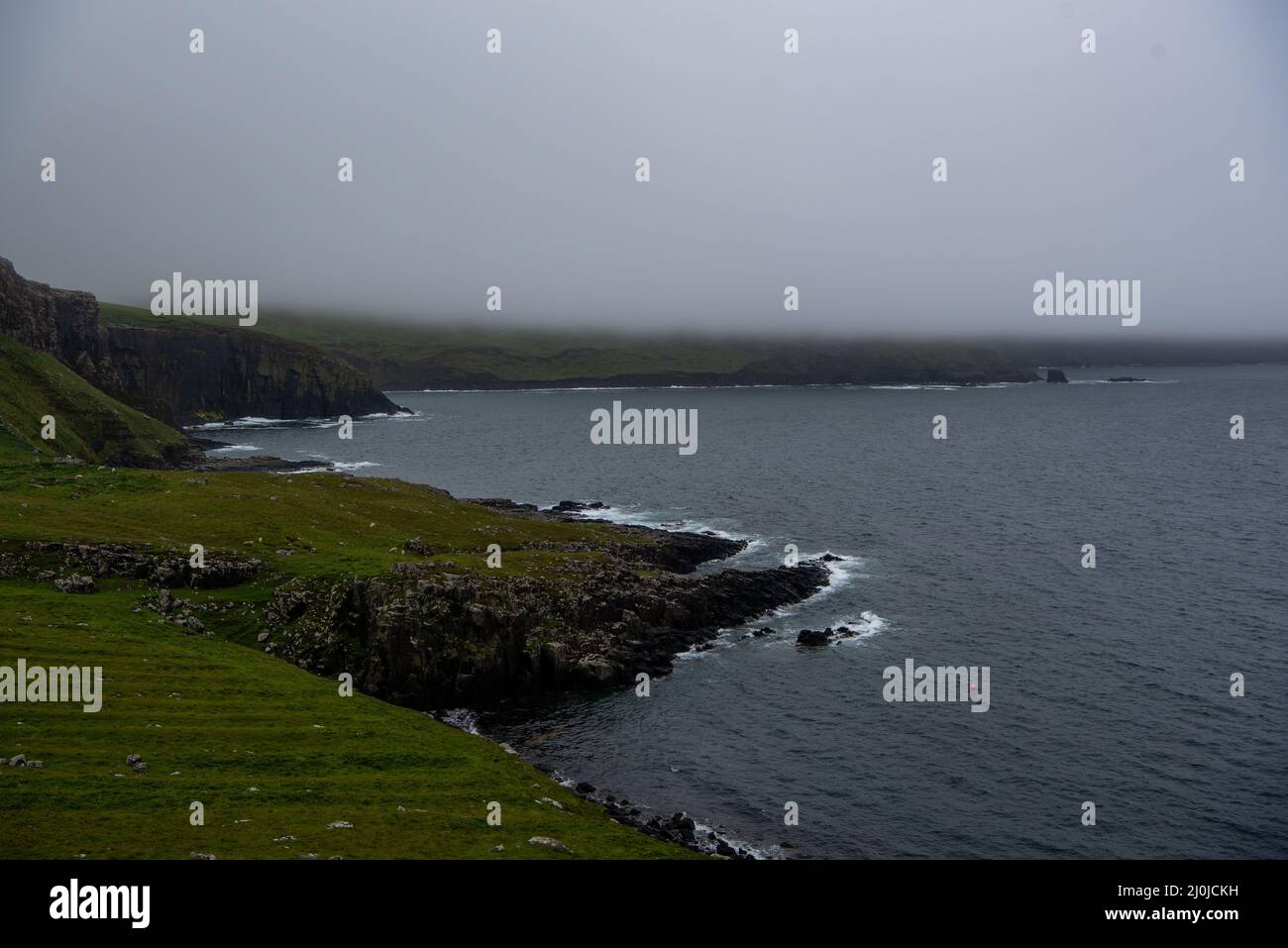 Aerial view of green cliffs near the shore on a gloomy day in Scotland ...