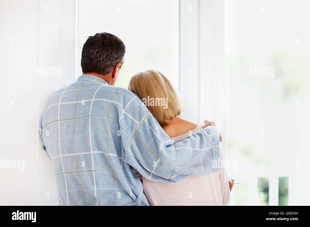 Romantic mature couple looking through glass window. Rear view of a ...
