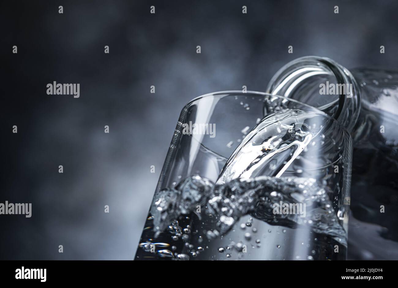 Pouring water on black background Stock Photo - Alamy