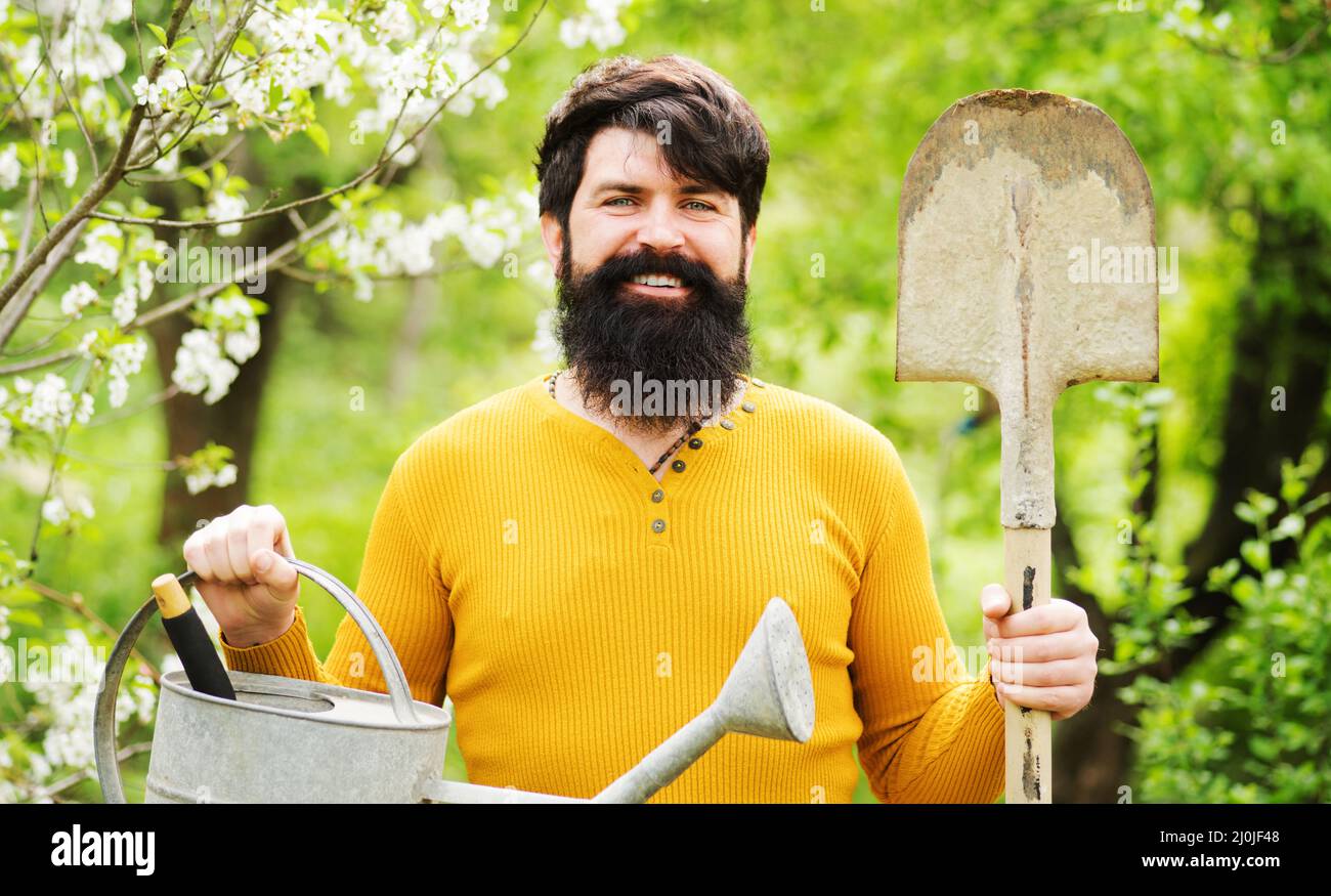 Bearded man with gardening tools. Gardener with shovel and watering can ...