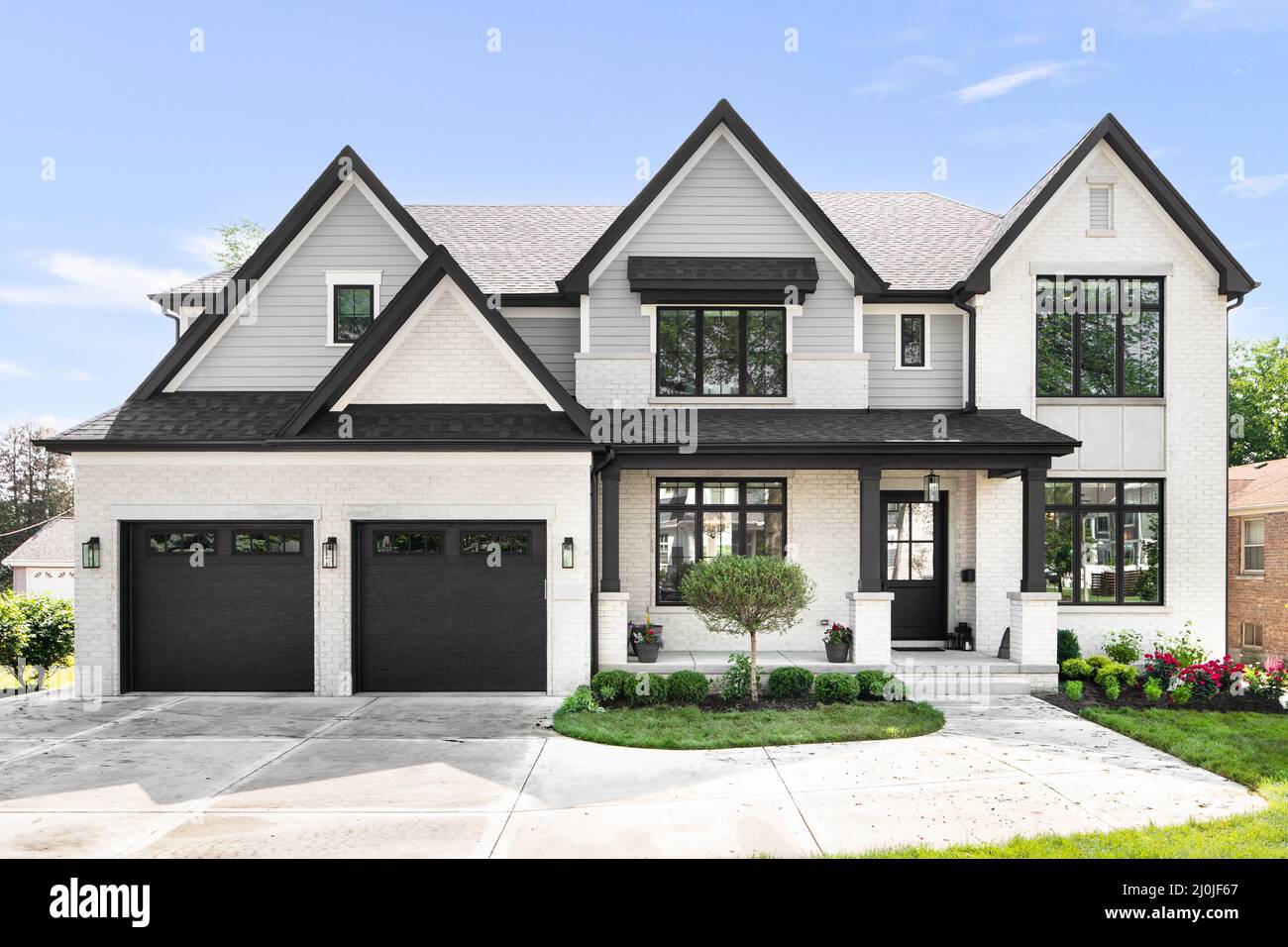 A beautiful modern farmhouse with grey siding and white brick, black ...