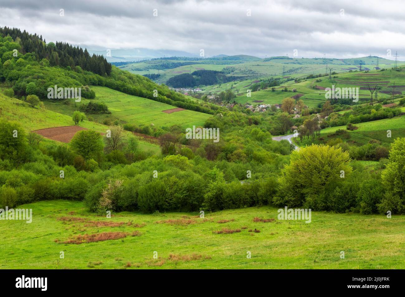 rural landscape on a rainy day in mountains. village in the distant ...