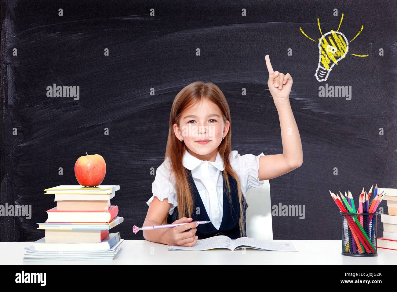 Young cute girl at chalkboard with light bulb over head Stock Photo - Alamy