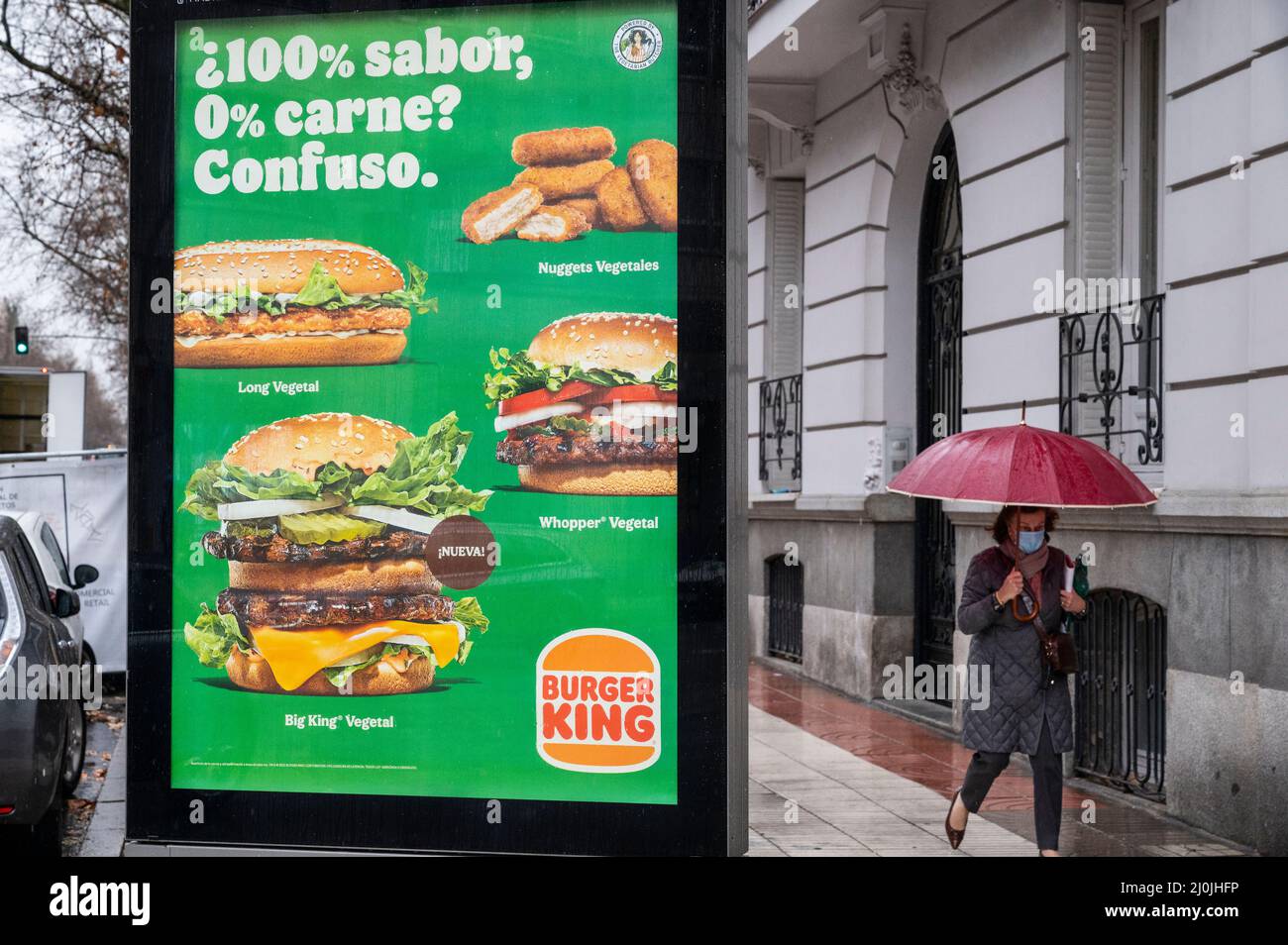 A pedestrian walks past a street commercial ad from the American fast ...