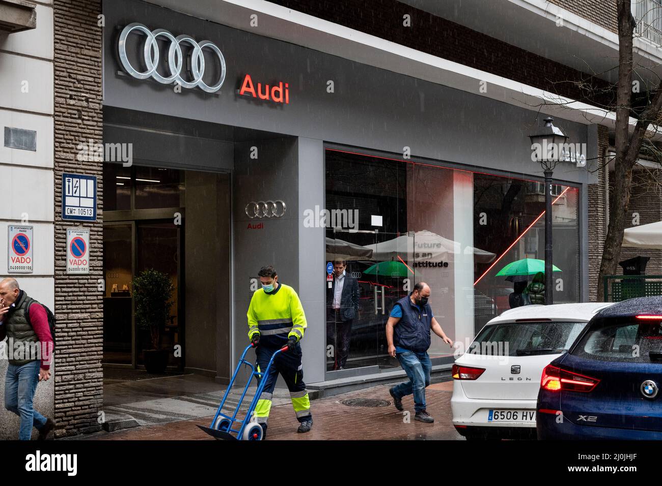 Pedestrians walk past the German automobile manufacturer Audi logo and ...
