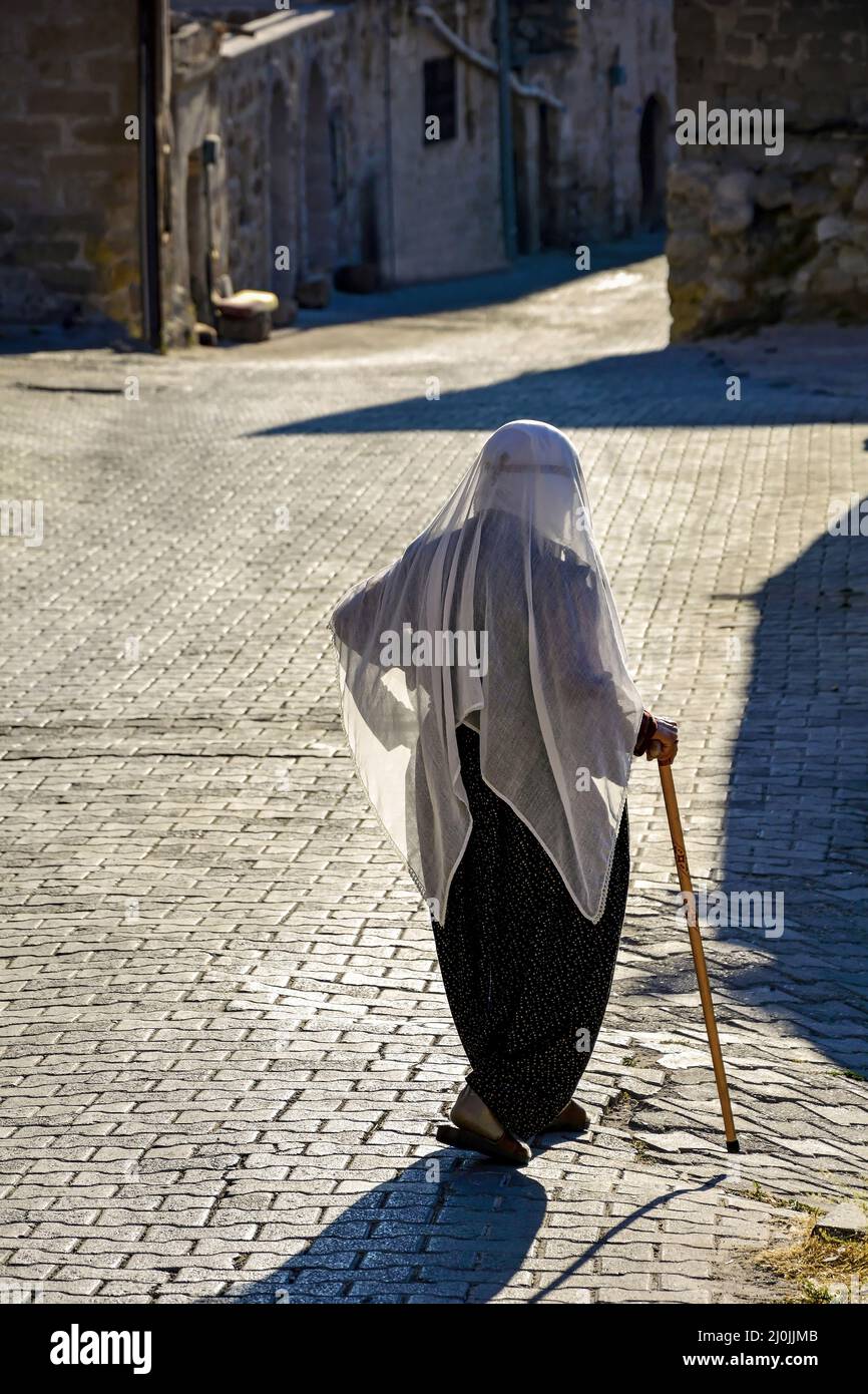 Old muslim lady walking by ancient street in Cappadocia Stock Photo - Alamy