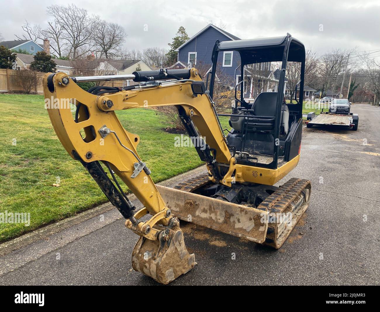 Yellow Industrial earth digger excavator parked on a road in a ...