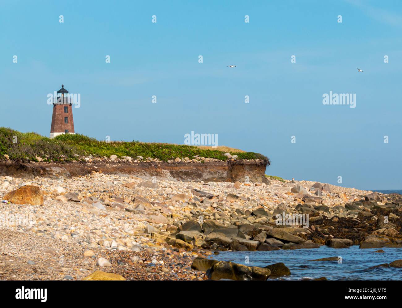 Heavely eroded beach of sand and stone beneath the Point Judith ...