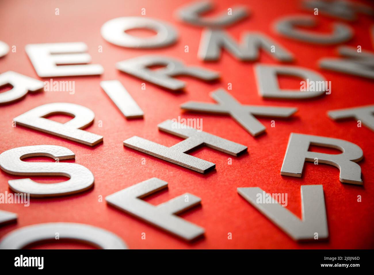 Mixed letters pile close up view photo. Red background Stock Photo - Alamy