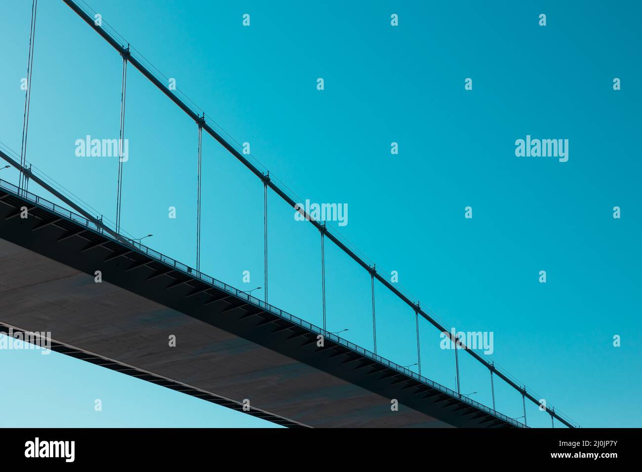 Suspension bridge. Hangers and cable of a suspension bridge isolated on ...