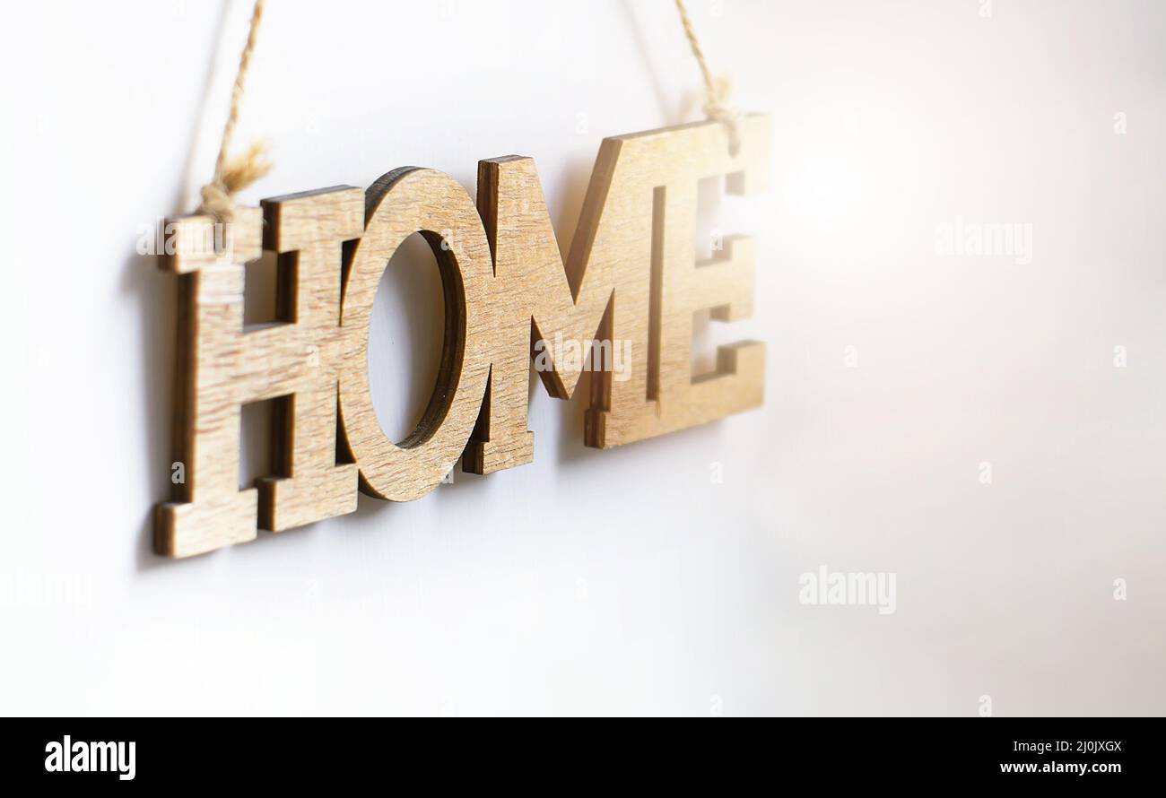 Home wood decorative lettering hanging on a white wall Stock Photo - Alamy