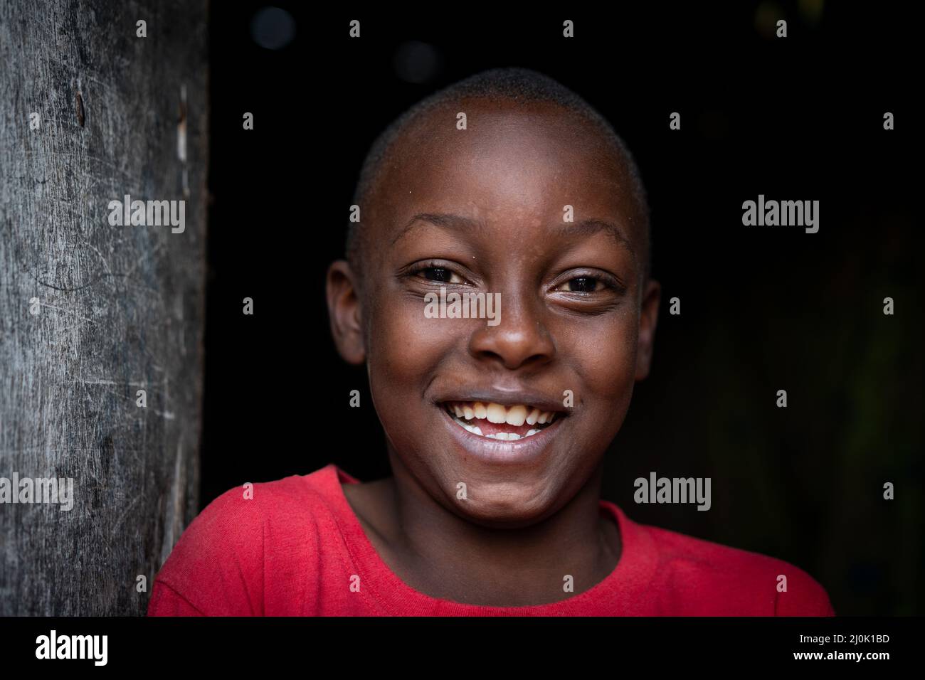 African black boy portrait standing near his poor house Stock Photo - Alamy