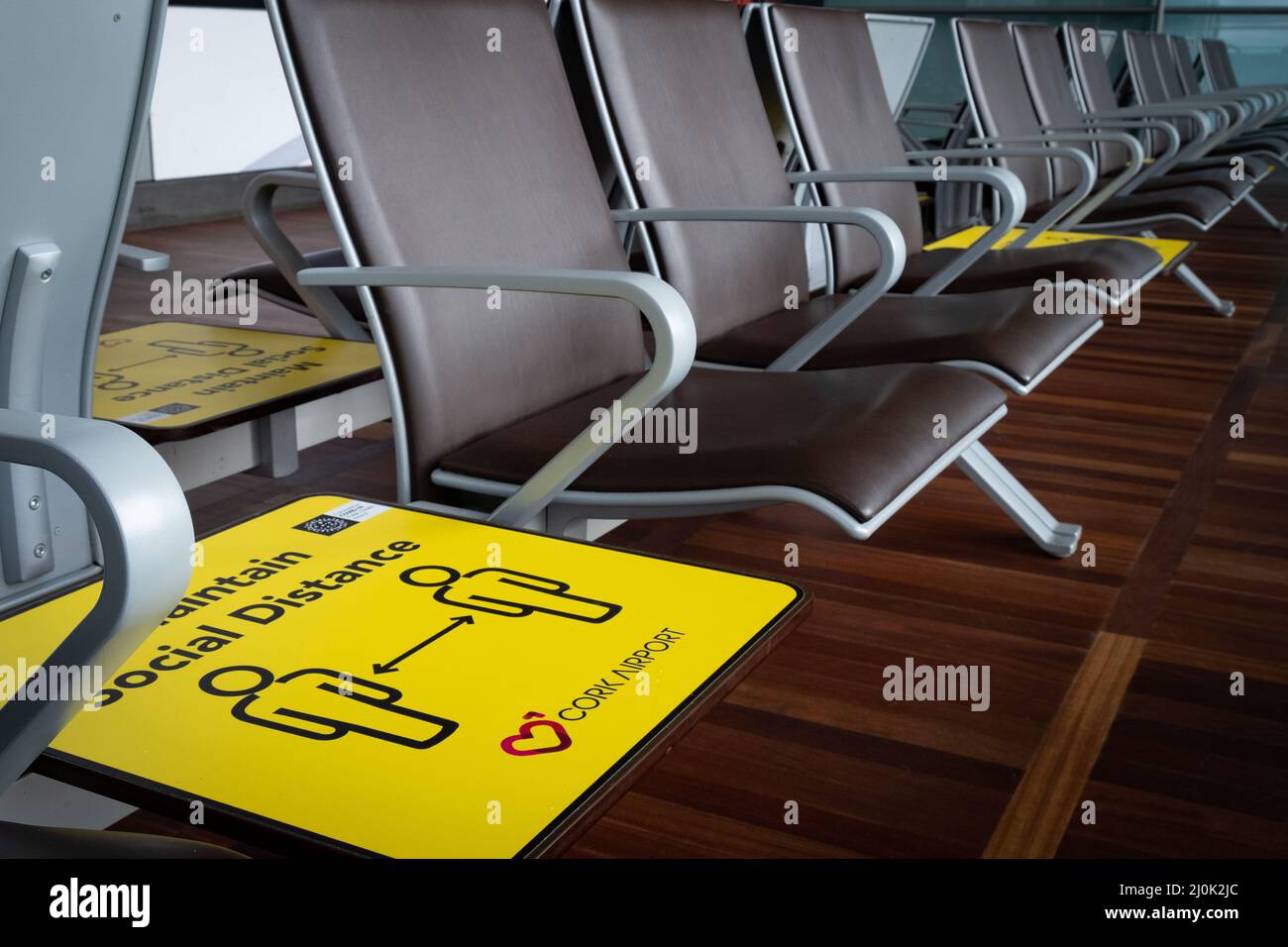Yellow social distance sign on terminal chairs at airport. Safety ...