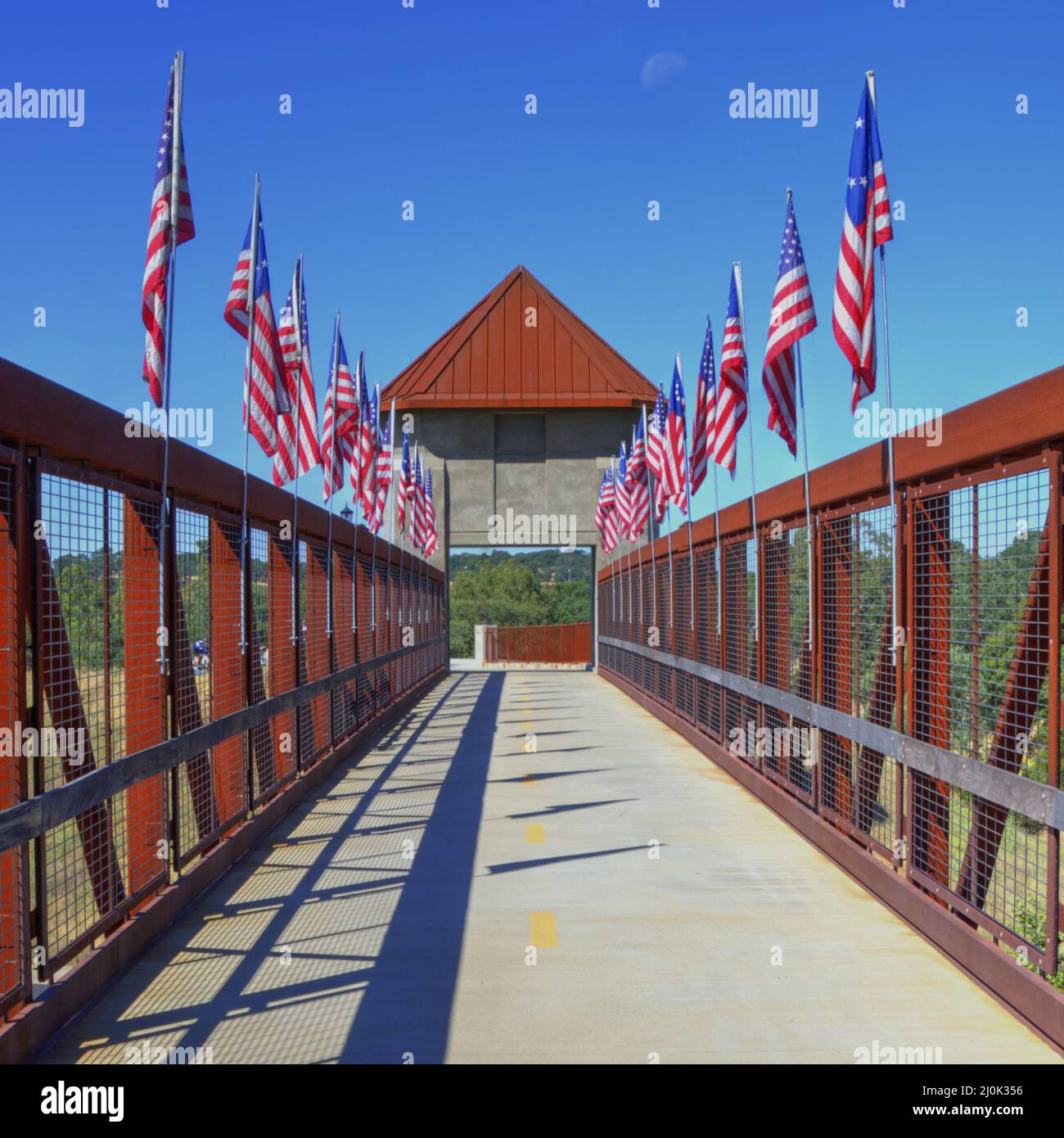 Bridge with American flags on both sides under the blue sky and the ...