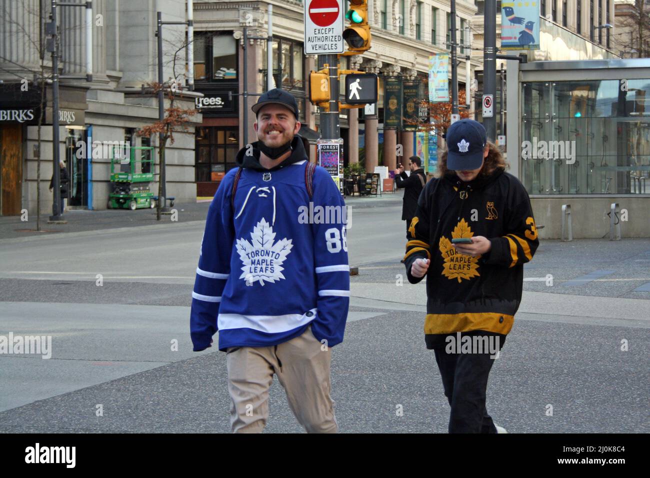 Young men in Maple Leafs jerseys walking in the street of downtown ... Young men in Maple Leafs jerseys walking in the street of downtown ...