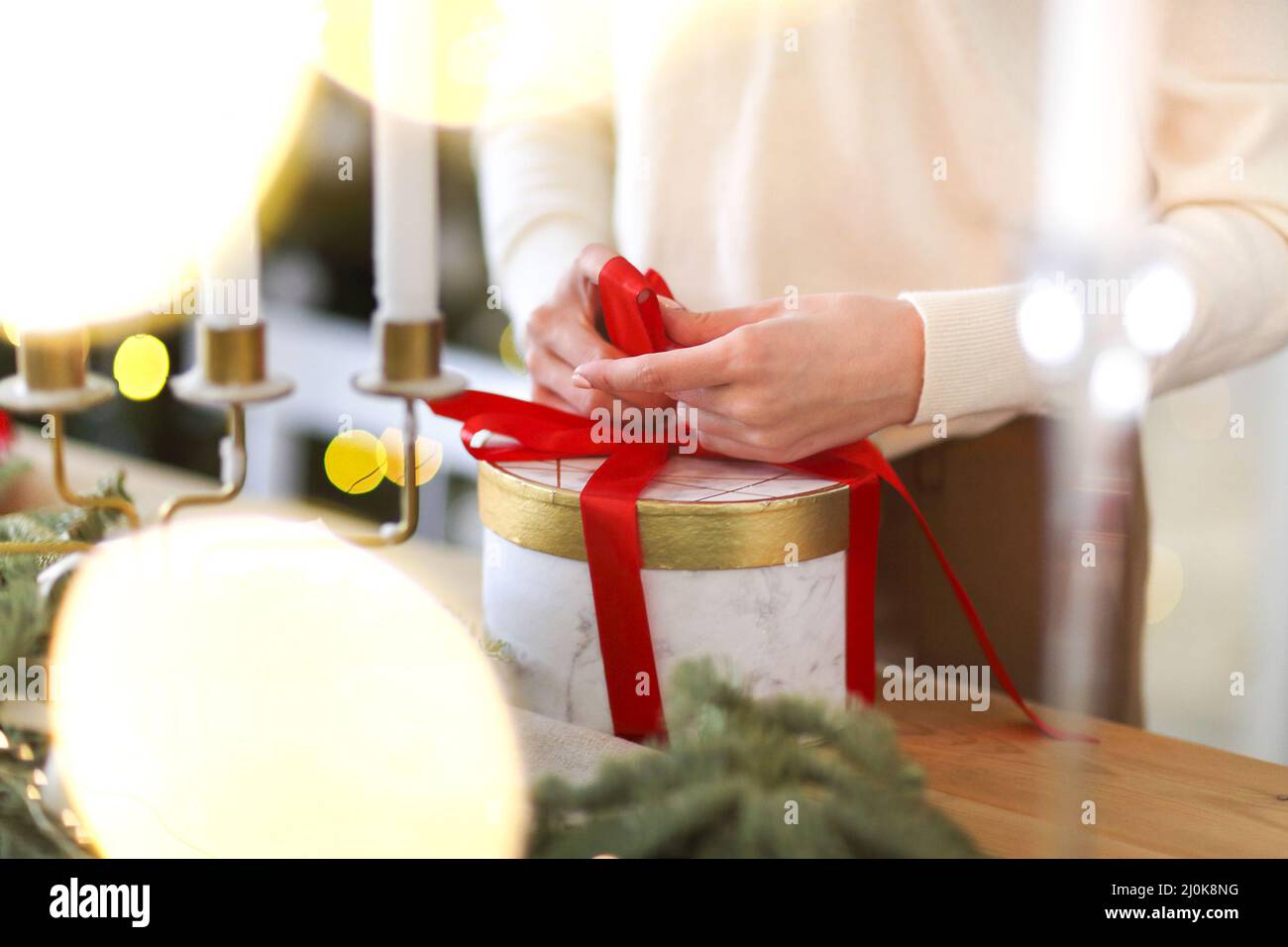 Crop female packing gift box with red bow Stock Photo - Alamy