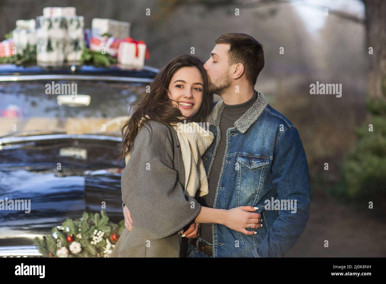 Couple kissing in vintage car with presents on roof Stock Photo - Alamy