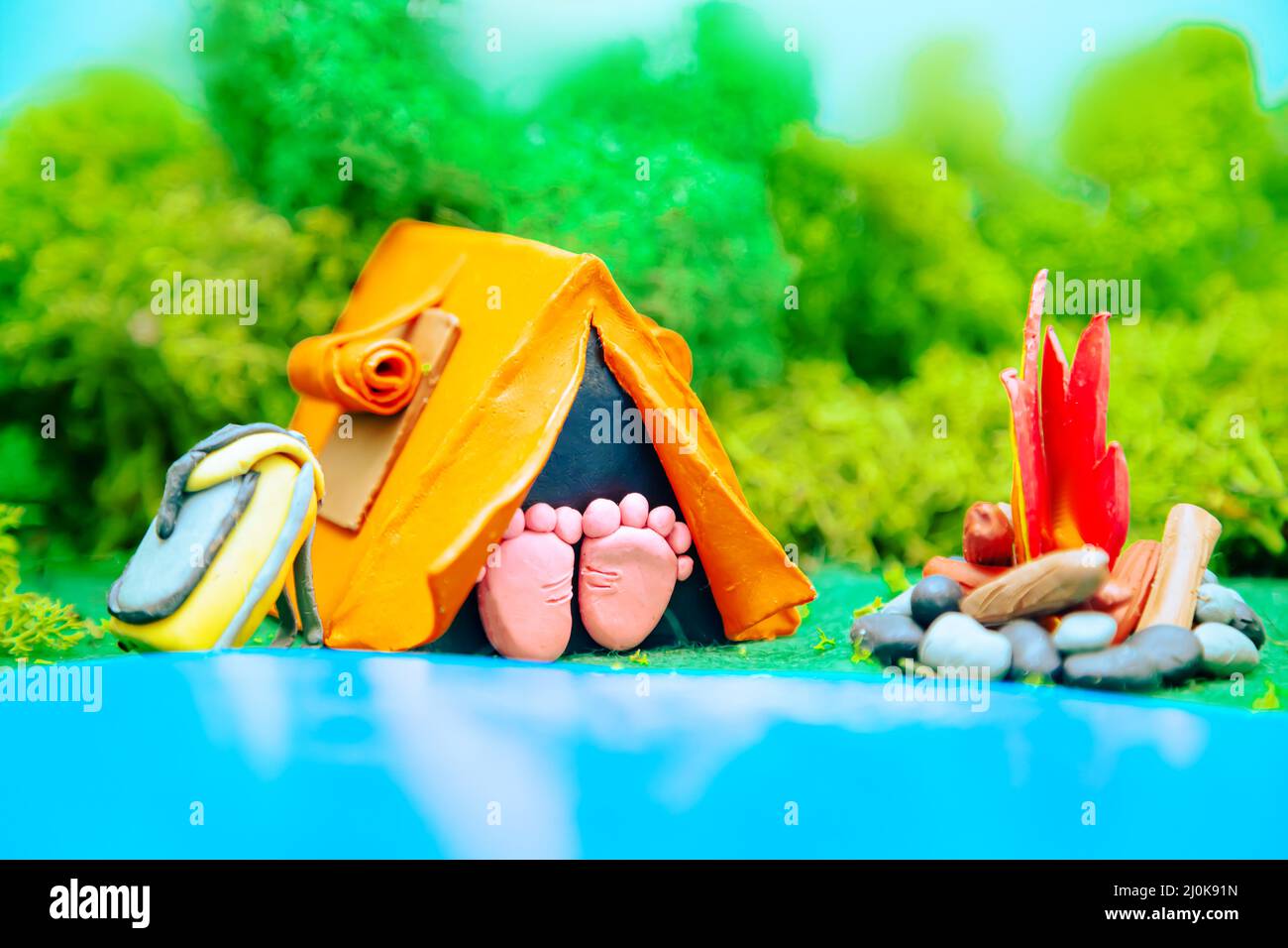 Tourist camp. Plasticine landscape with a tent, a campfire and a ...