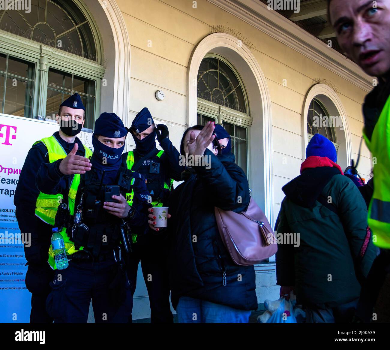 A polish police officer directs a refugee at a train station. Ukrainian ...