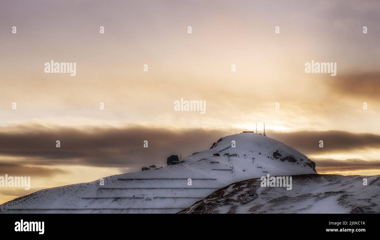 Stunning winter landscape of snow-capped rocky mountains under a cloudy ...